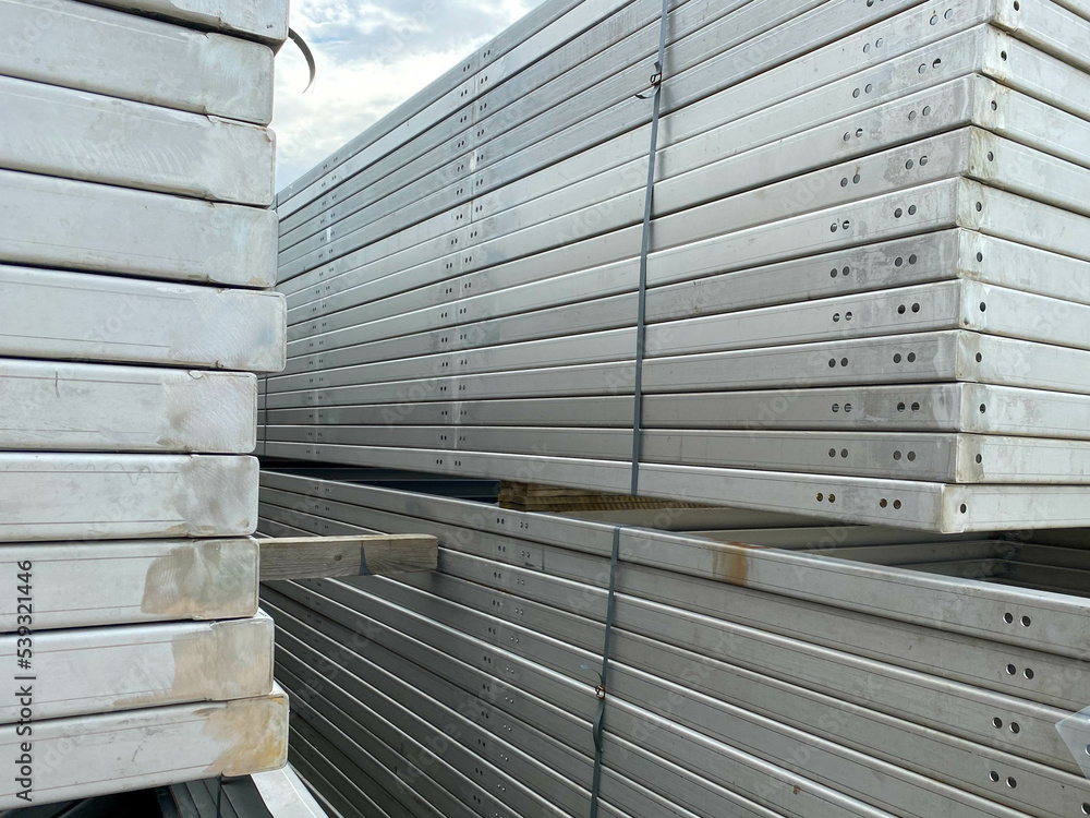 Metal structures for construction and pipes on pallets in an open-air ...