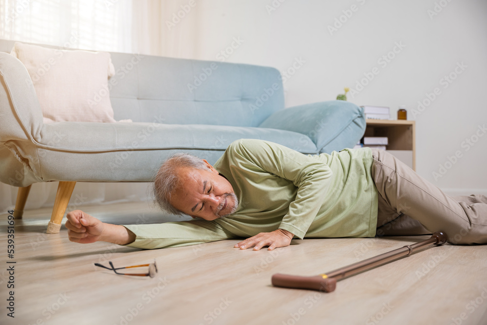 Asian old man lying on floor after falling down with wooden walking ...