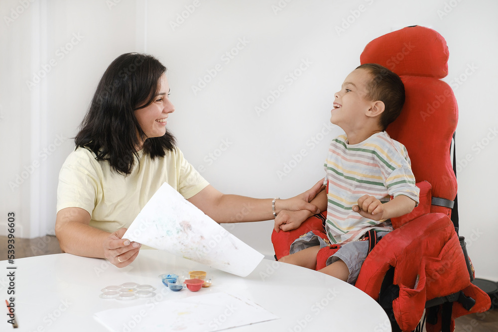Child with cerebral palsy painting with fingers and hands boy that has ...