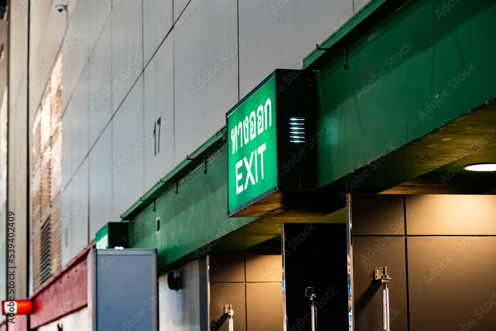 Large Emergency exit sign green light box is placed on the wall of ...