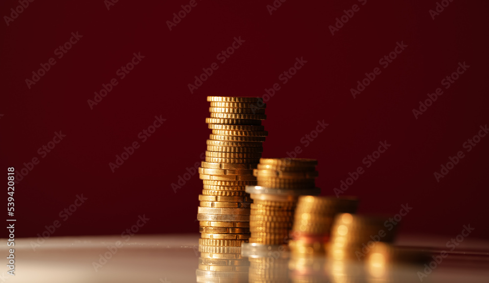 Coin tower made of European currency against dark red background ...