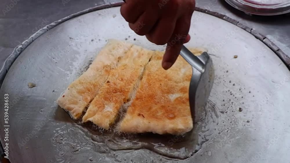 street food in thailand Crispy flour roti on a large flat pan The chef ...
