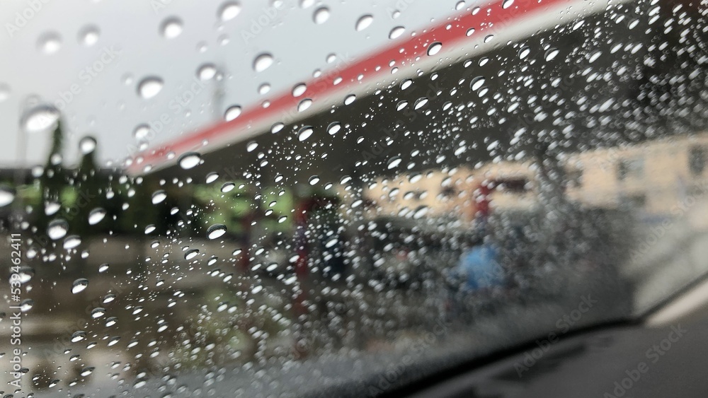 Rain falling on car windshield,drive car on street in city at heavy ...