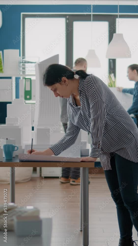 Vertical video: Woman architect designing blueprints plans with ...