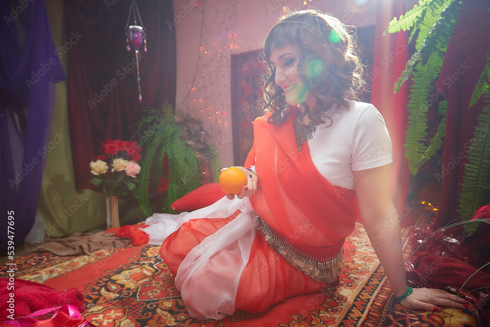Beautiful European girl looking like Arab woman in red room with rich ...