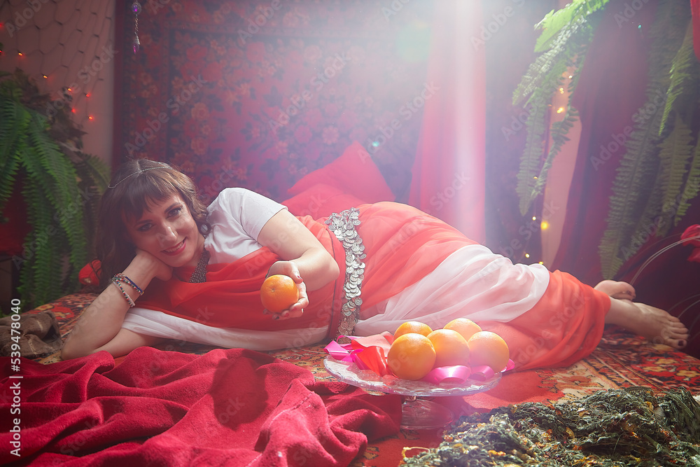 Beautiful European girl looking like Arab woman in red room with rich ...