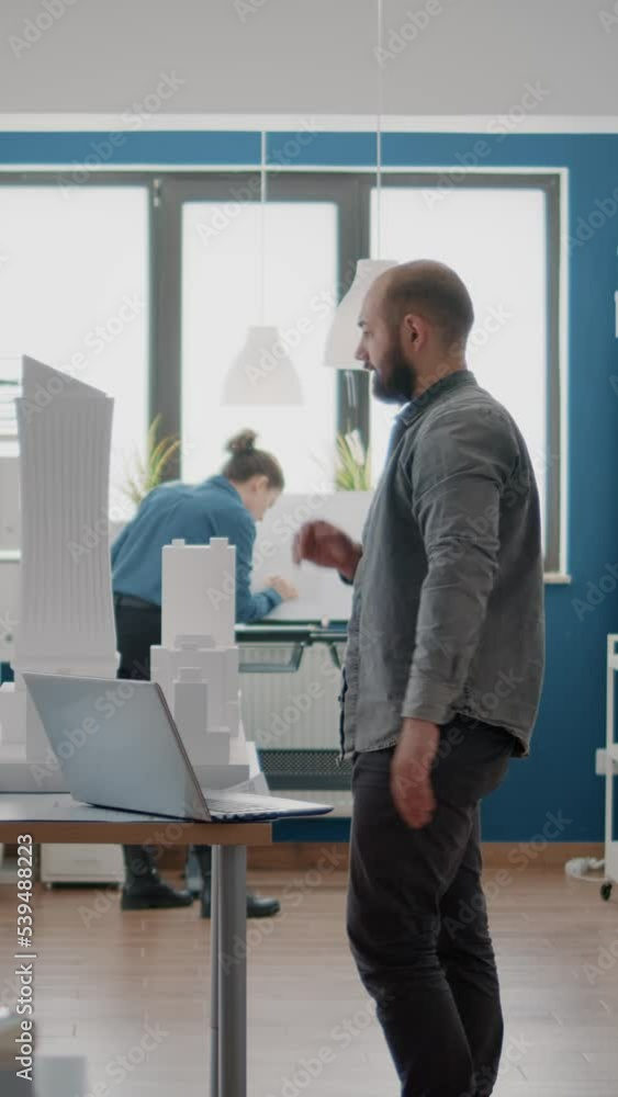 Vertical video: Architectural worker using laptop to design building ...