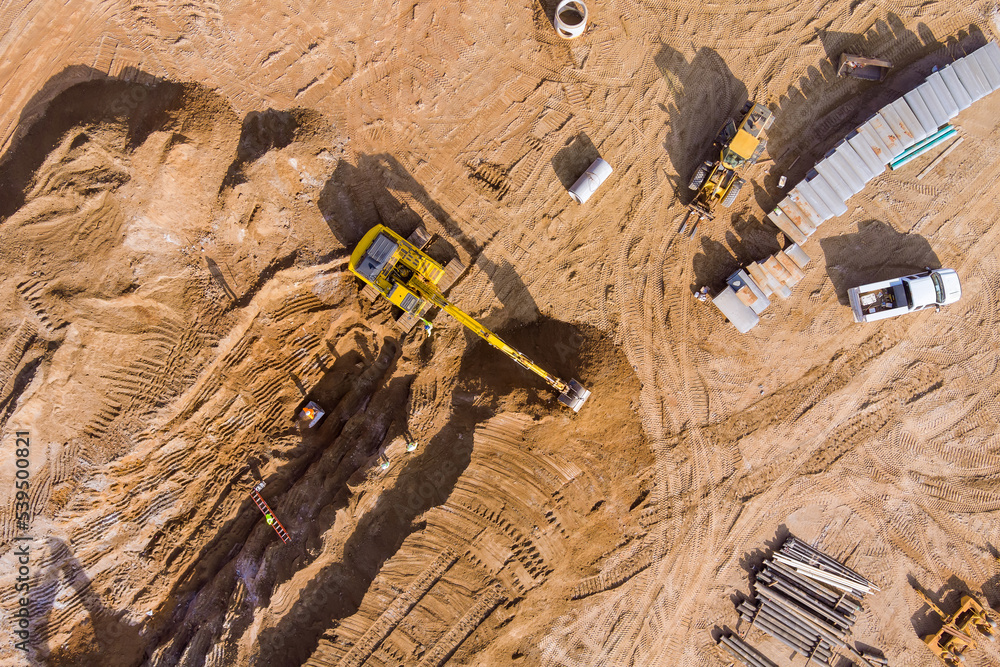 Construction site excavator digs trench to lay sewer line and connect ...