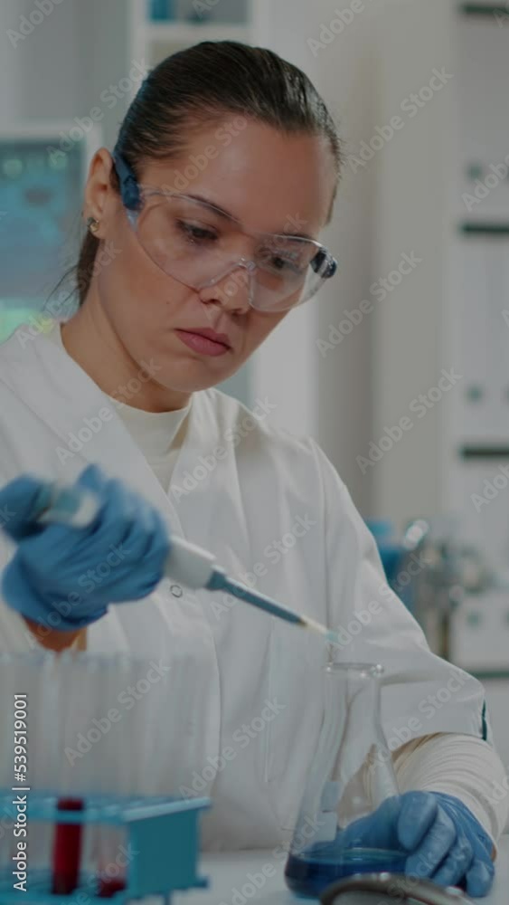 Vertical video: Lab worker using micro pipette with beaker and test ...