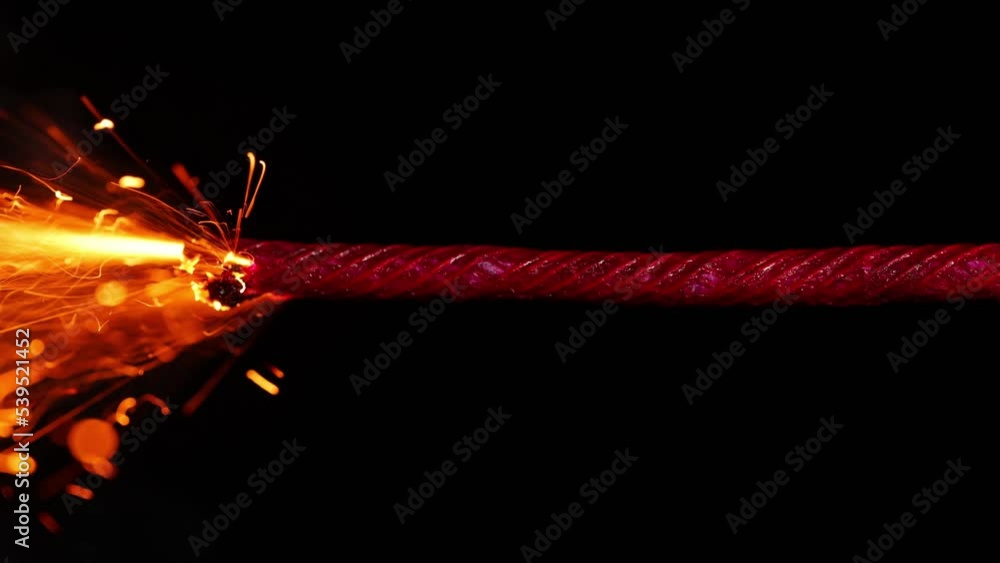 A macro shot of a burning fuse in front of a black background. Slow ...