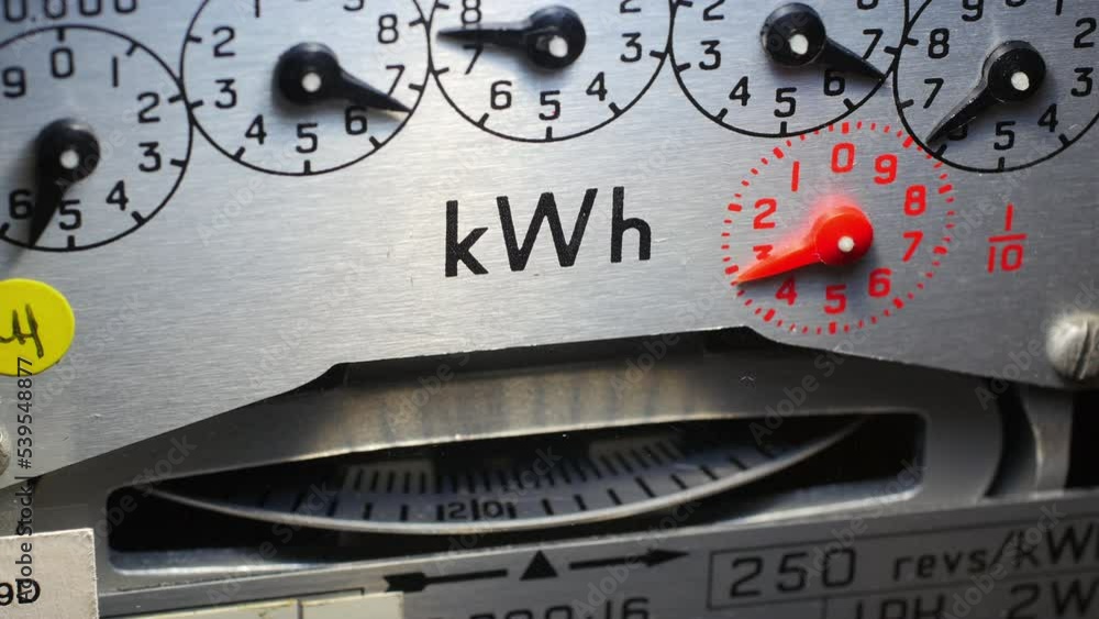 A close-up of an electric meter and digits. A turning dial showing ...