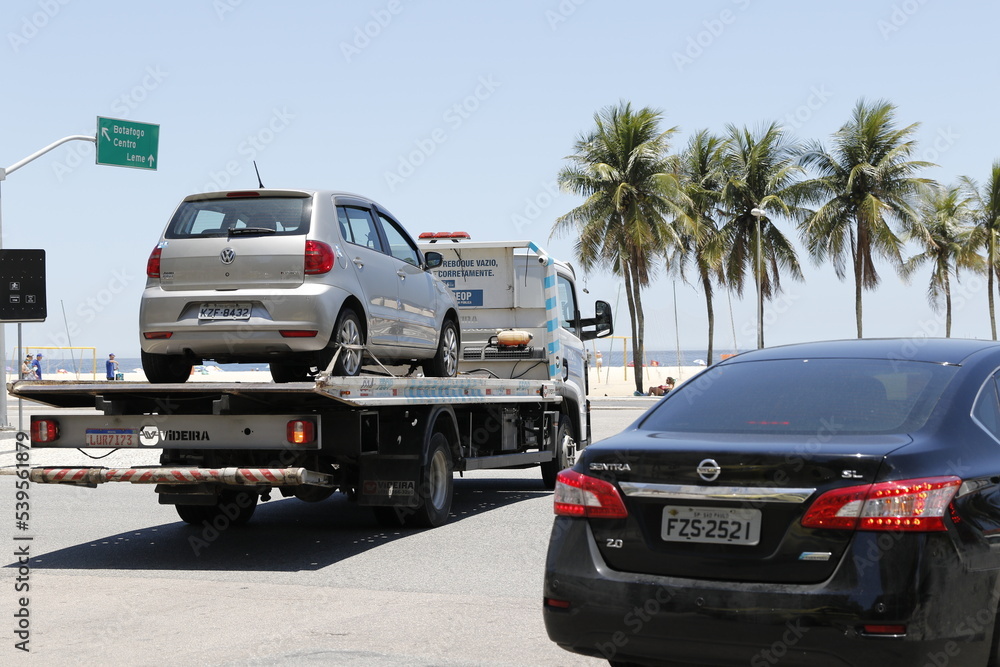 Tow truck towing impounded vehicles for traffic violations. Illegal ...