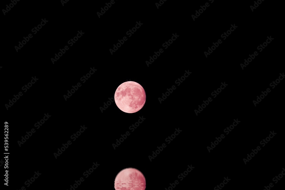 Big RED full moon in the starless sky at night and the reflection on ...