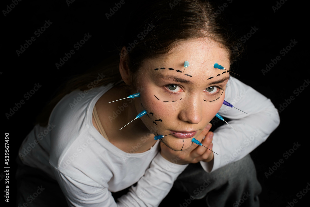 young beautiful girl looking into the camera. needles from syringes and ...