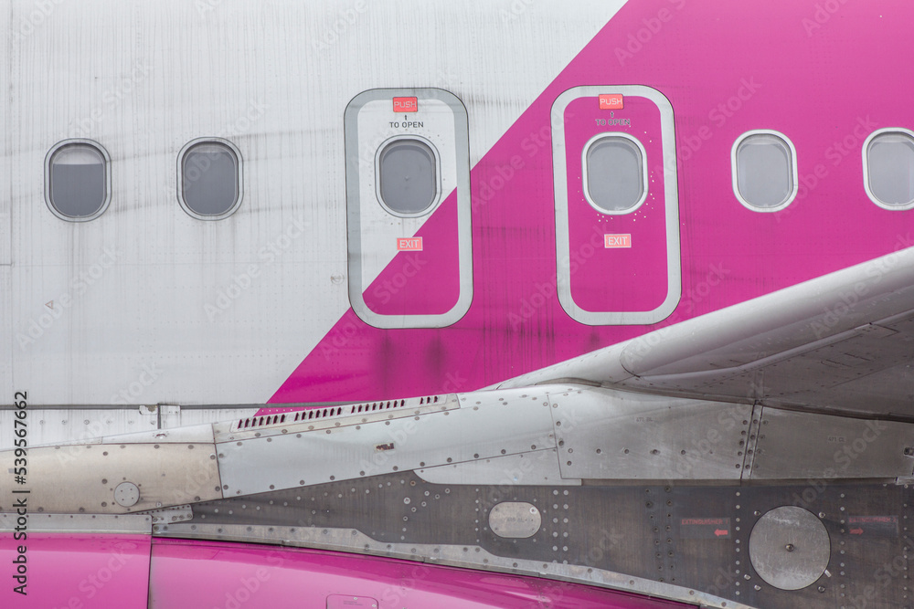 Foto de White and pink fuselage of a passenger jet airliner with ...