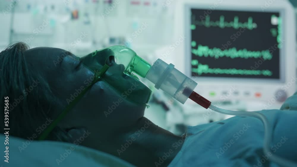 A female patient in medical mask is breathing oxygen support in a ...