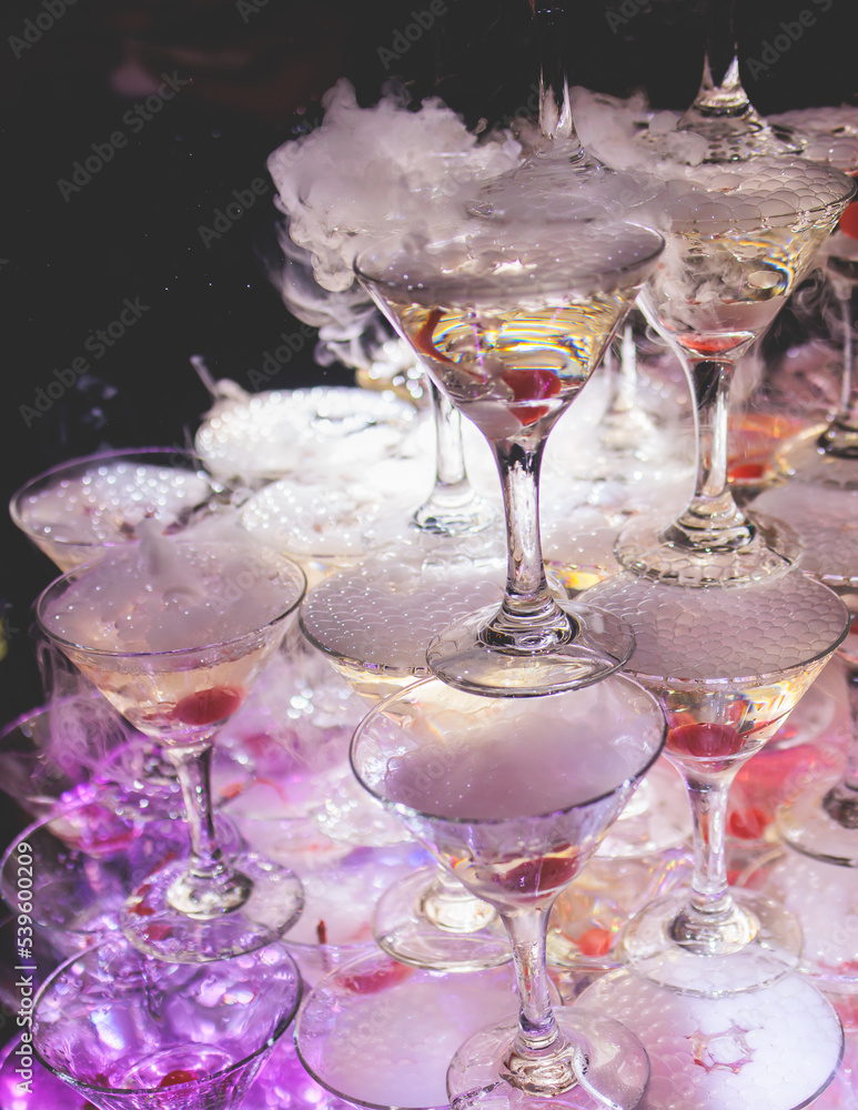 Pyramid of glasses with alcoholic beverages, filling and pouring ...