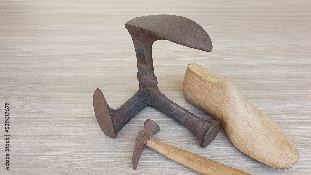 Shoemaker's anvil, wooden shape of shoe and hammer. Old shoemaker's ...