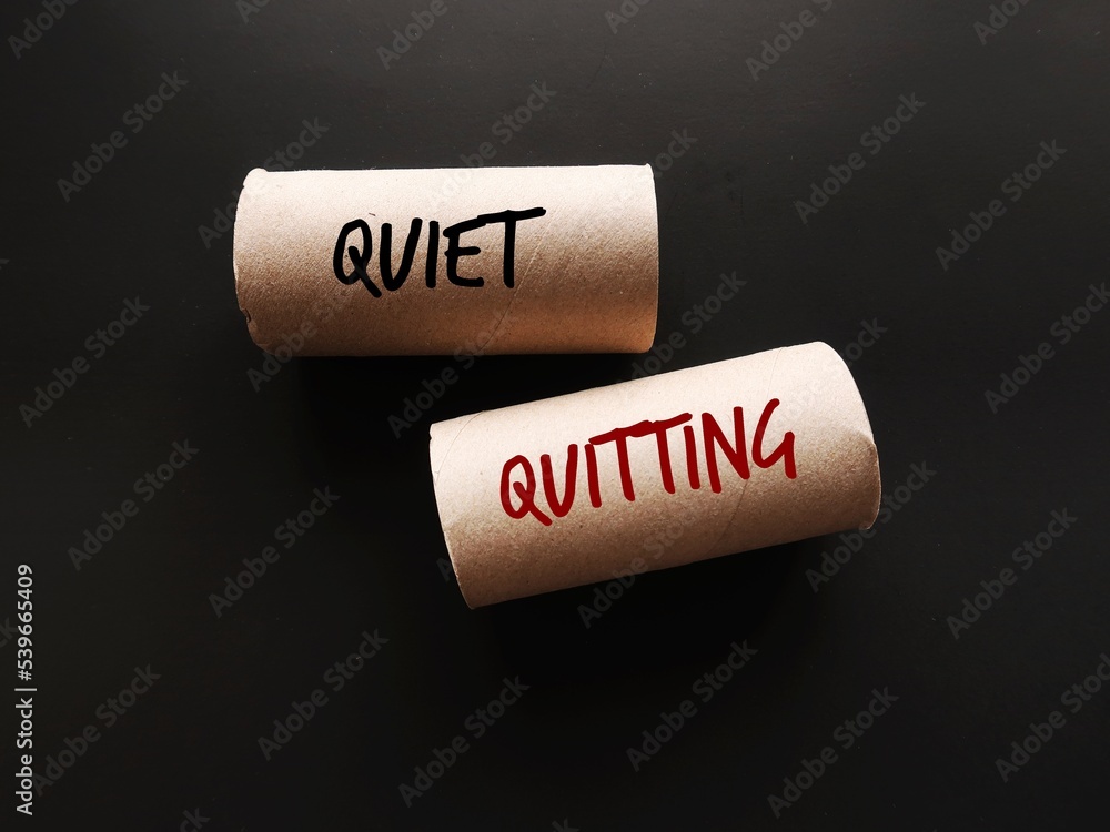 Toilet paper on black background with handwritten words QUIET QUITTING ...