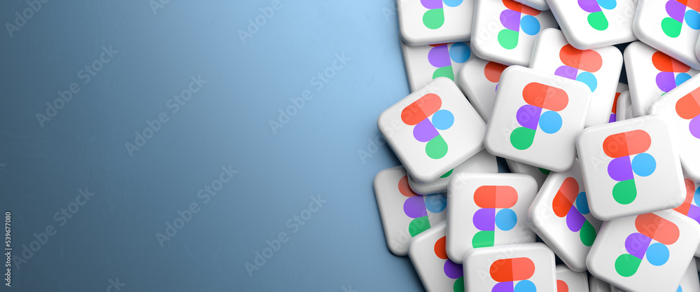 Logos of Figma, the platform for collaborative web and interface design, on a heap on a table ...