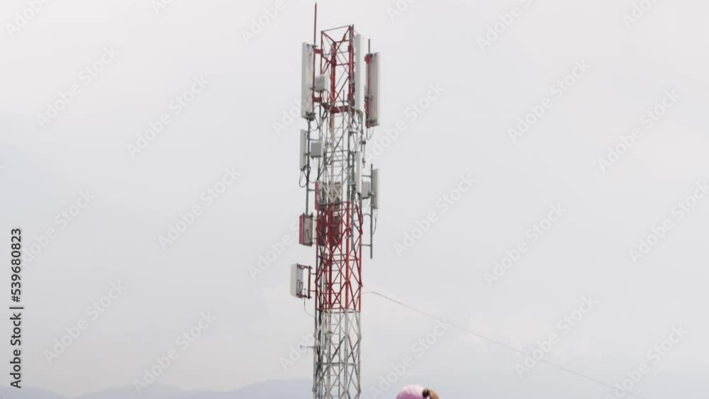 Hiker girl in nature with communication tower in the background. Back ...