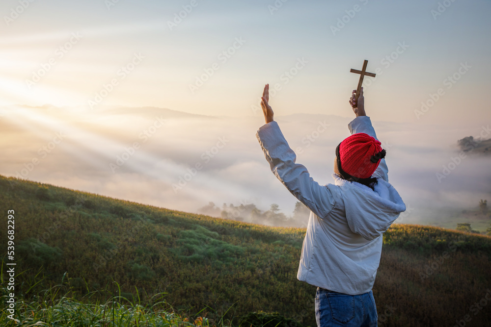 Child holding christian cross Prayer to God beautiful sunrise or sunset ...