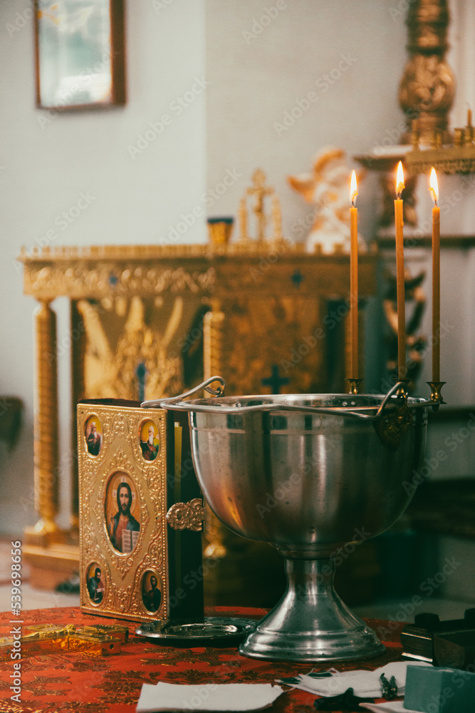 Lit church candles and baptismal font, church paraphernalia inside the ...