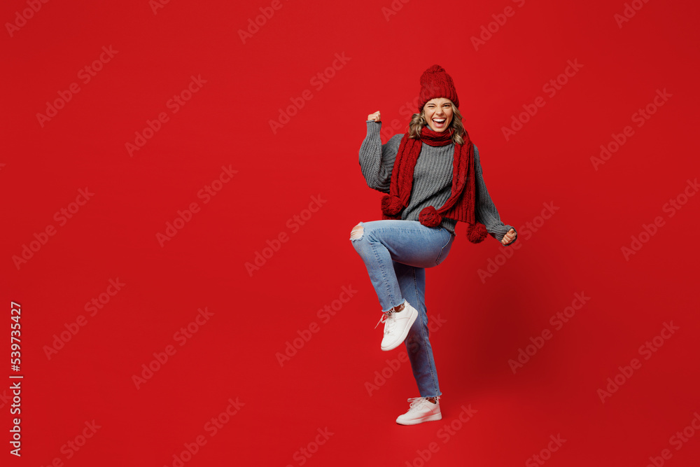 Full body young woman wear grey sweater scarf hat do winner gesture ...