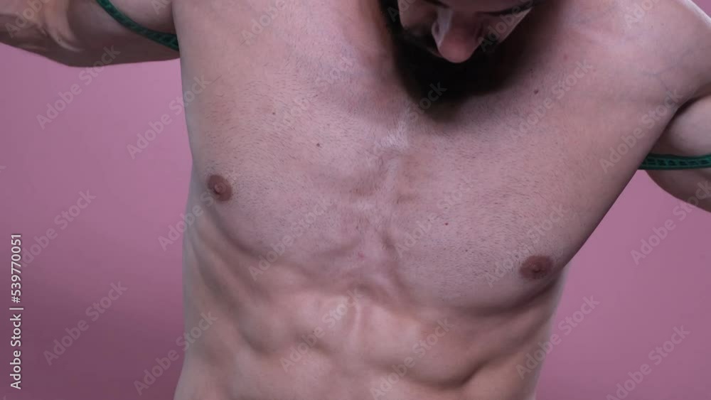 Strong shirtless bodybuilder measuring his chest width with a measuring ...