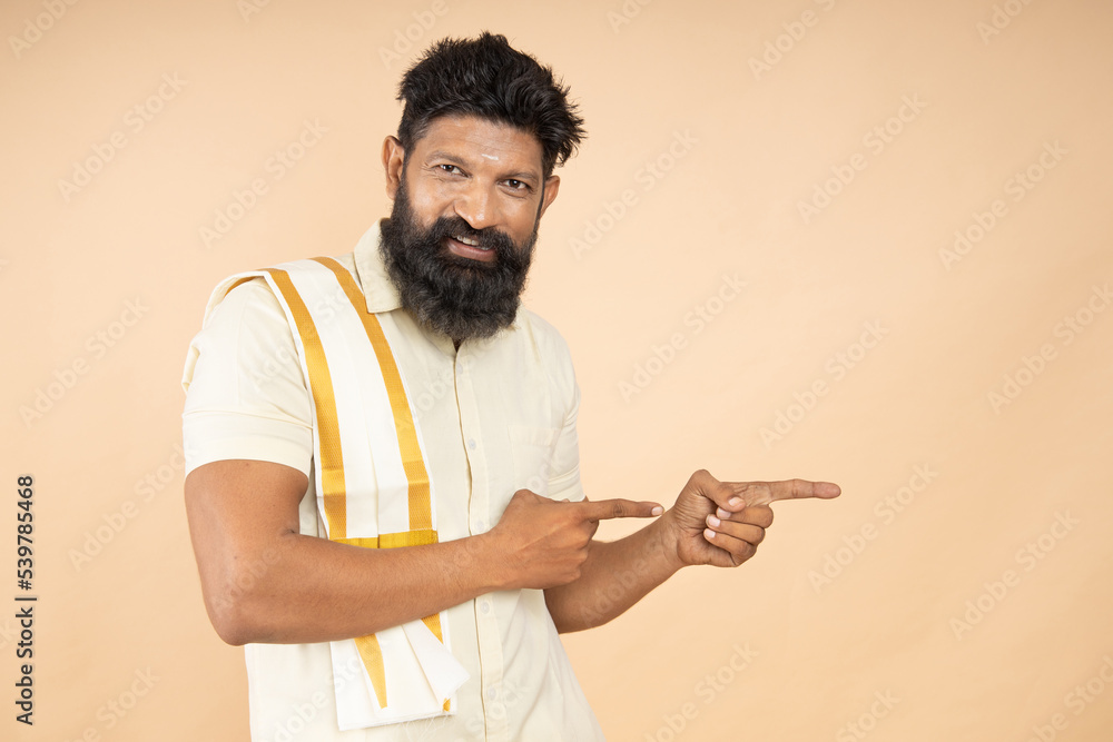 Happy South indian man point finger at blank space for your promotion ...