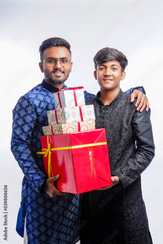 Two handsome men wearing traditional outfit Kurta and holding gift ...