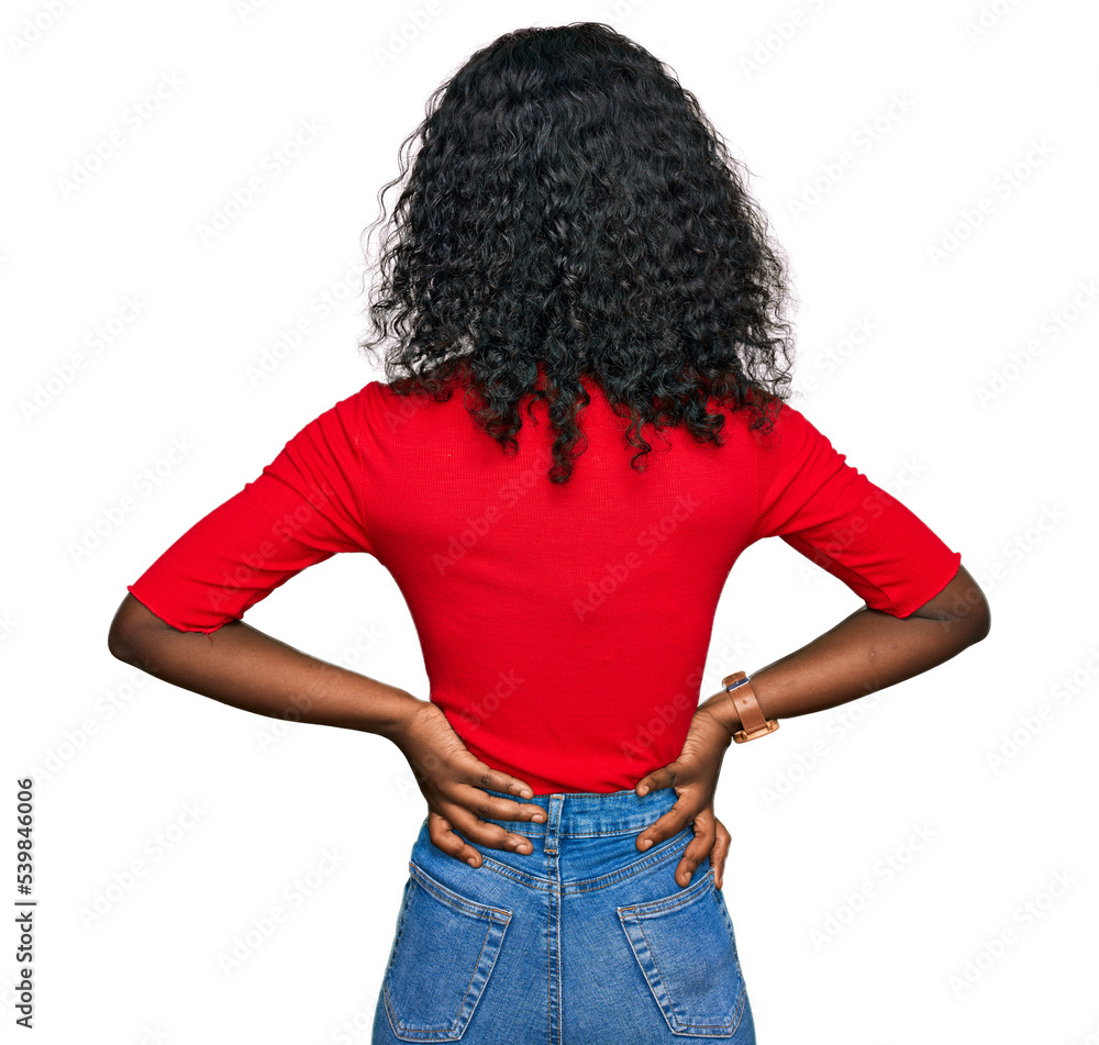 Beautiful african young woman wearing casual clothes standing backwards ...