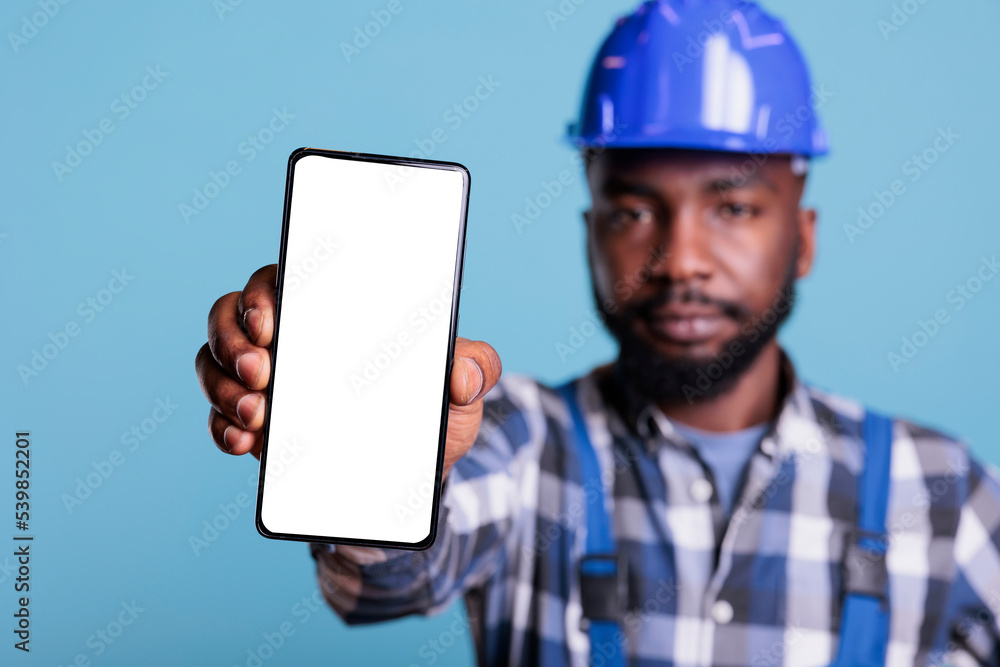 Serious construction worker showing modern phone with blank white ...