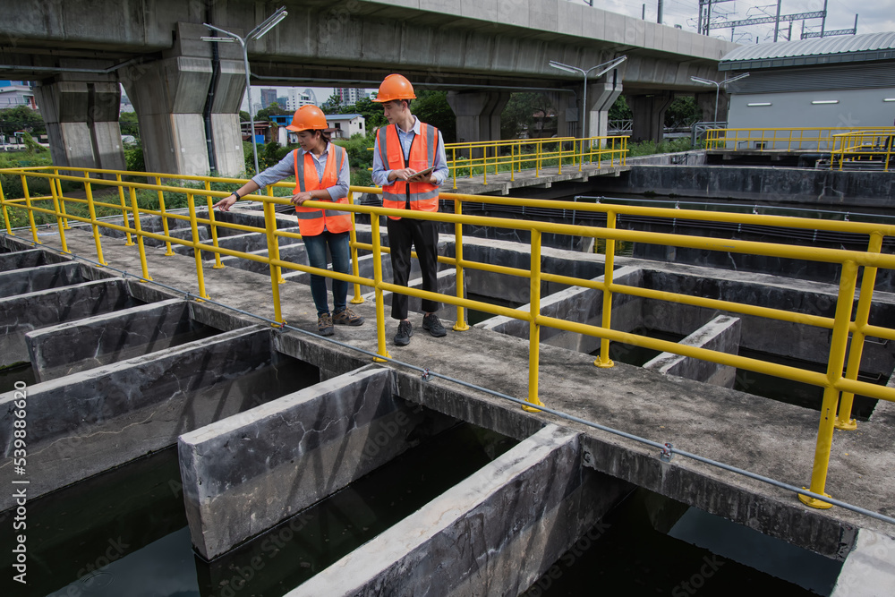 workers at work. service engineer checking on waste water treatment ...