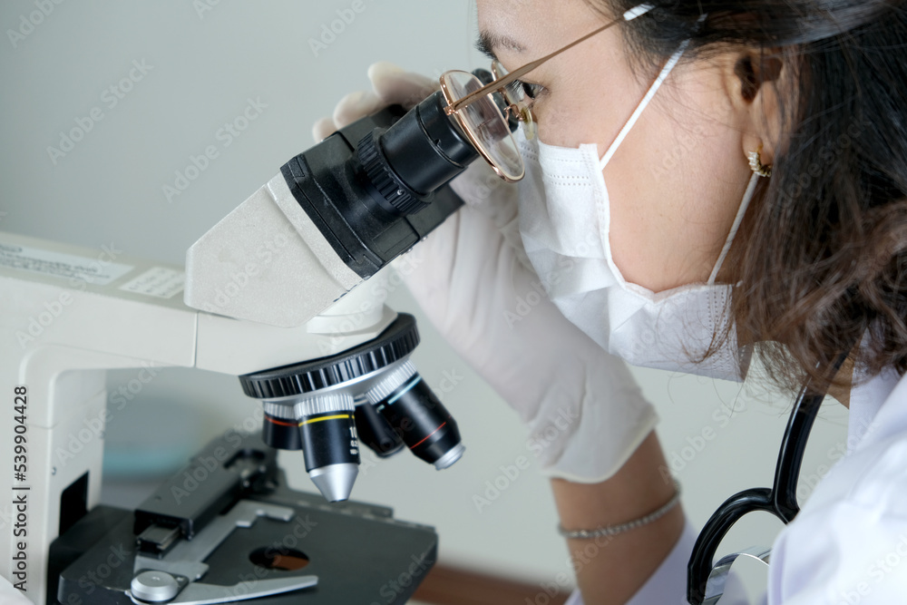 Cientist, she looks through the camera to see the details and ...