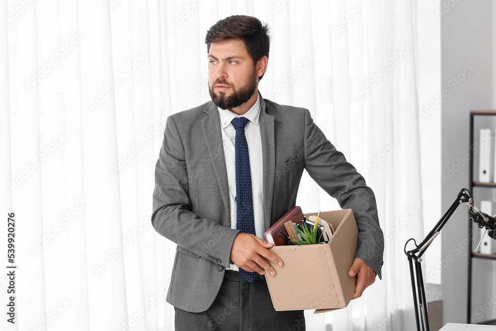 Fired young man holding box with his stuff in office Stock Photo ...