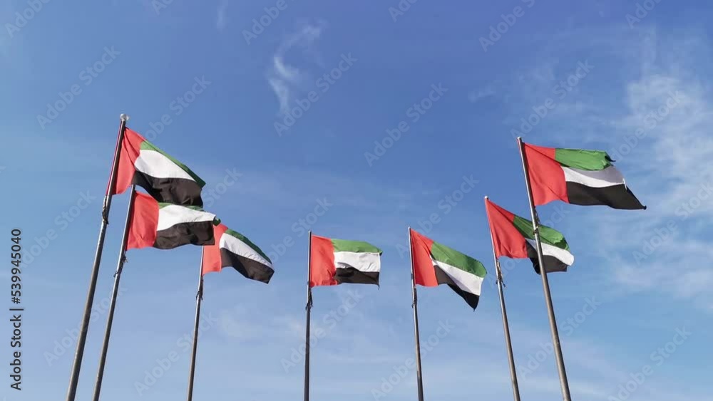 National symbol of United Arab Emirates flags in blue sky background ...