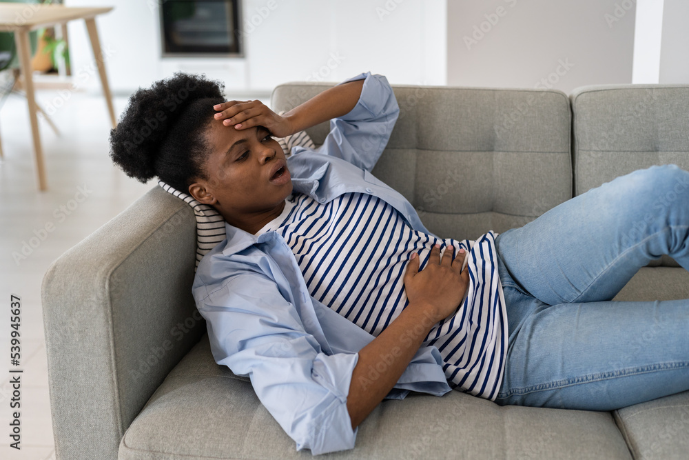 Sick young African American woman having health problems holding head ...