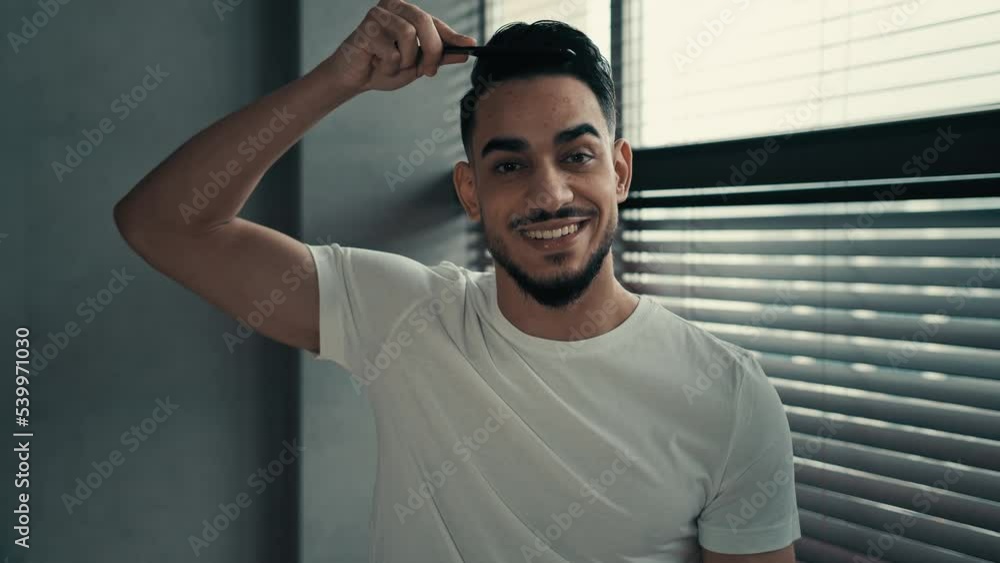 Smiling Hispanic Indian Latina bearded man looking at camera combing ...