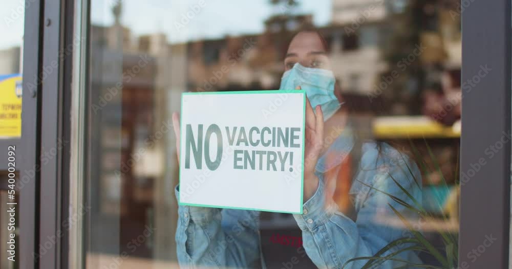 Sad depressed woman wearing face mask attaching sign on the glass in ...