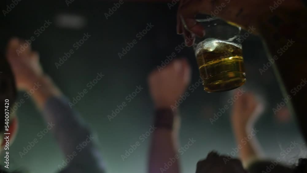 Crowd at a concert cheering. Indoor festival nightlife. beer in hand ...