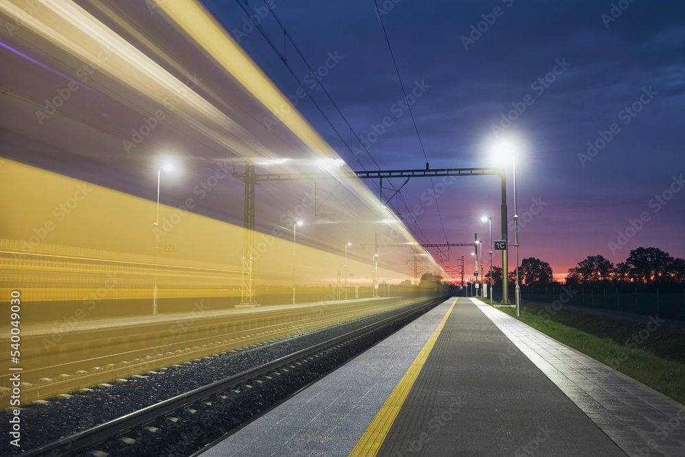 Foto de Modern railway at beautiful dawn. Light trail of high speed ...