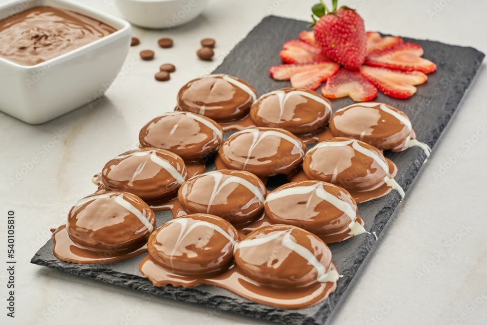 Plate full of mini pancakes drizzled in chocolate sauce. Stock Photo ...