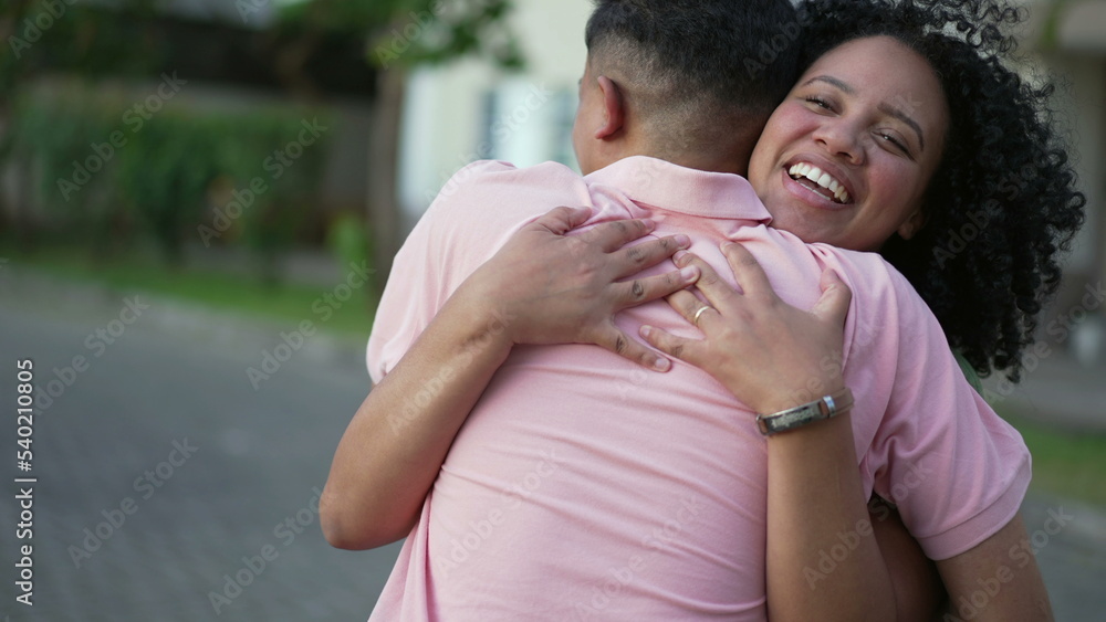 Two happy people embracing celebrating reunion. Young woman hugging ...