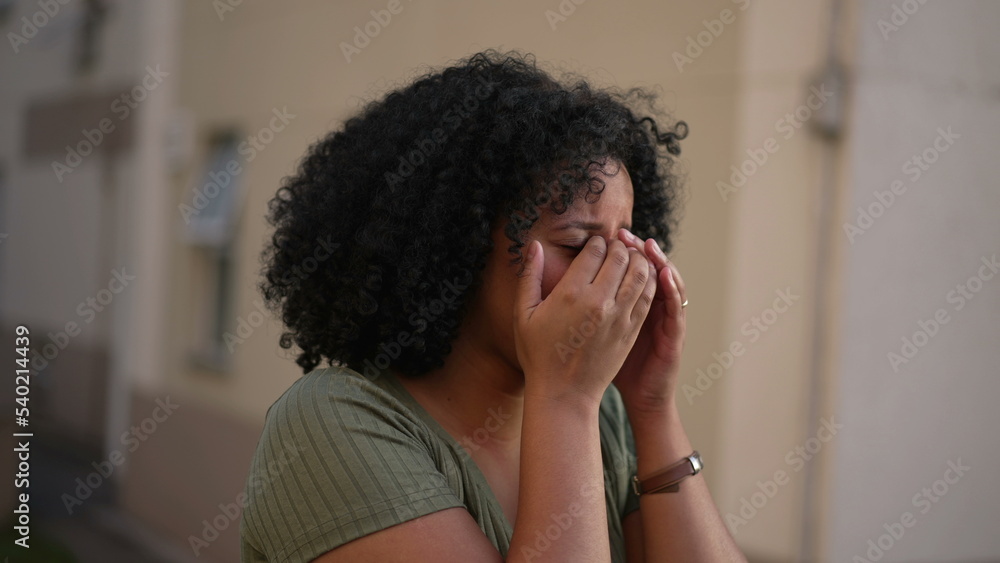 Foto de One crying young black woman covering face in despair. Tearful ...
