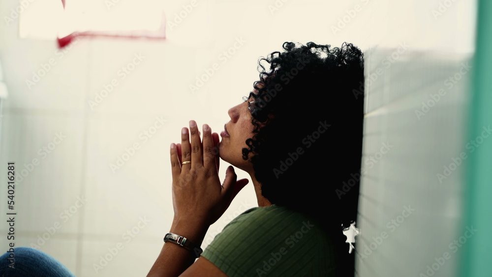 Faithful hispanic young woman praying to God during difficult times ...
