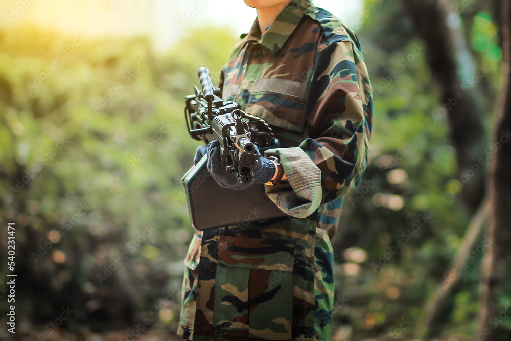 US Army handling M249 LMG during the military operation in the forest ...