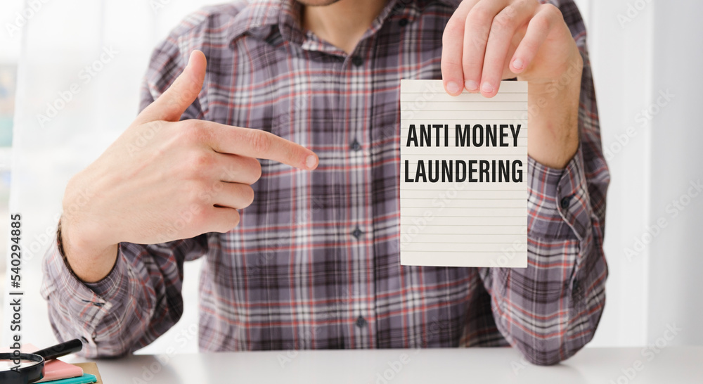 Anti-money laundering AML text on a clipboard on light background with ...