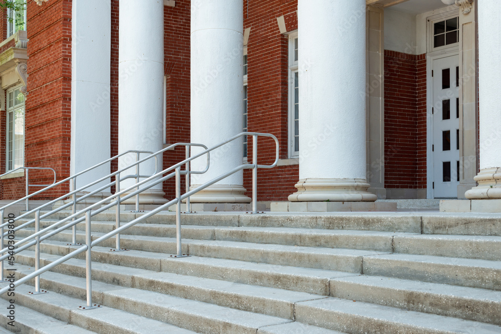 Four large white round columns at the facade entrance to a red vintage ...