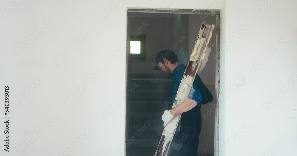 Construction handyman works on apartment renovation demolishes door ...